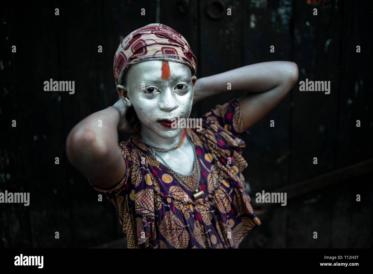 A girl with a silver painted face seen posing for a photo during the ...