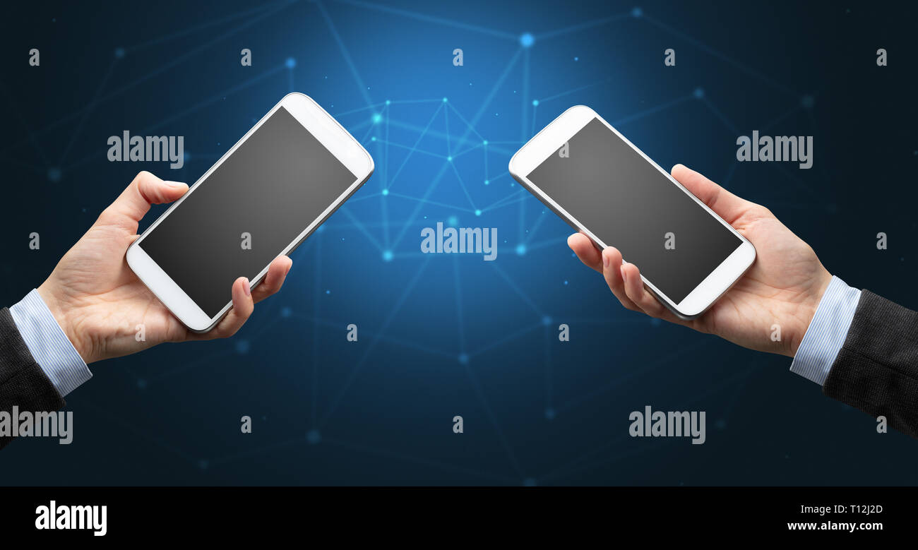 Close up of two hands holding smartphones to each other, wireless ...