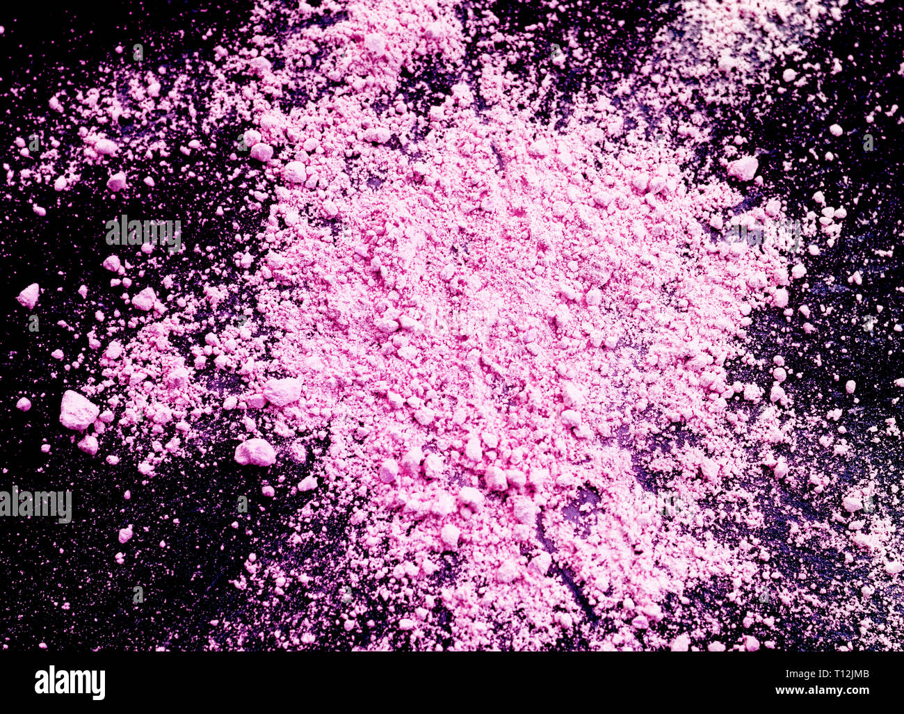 Pile of natural colored pigment powder. Pink powder particles splatter ...