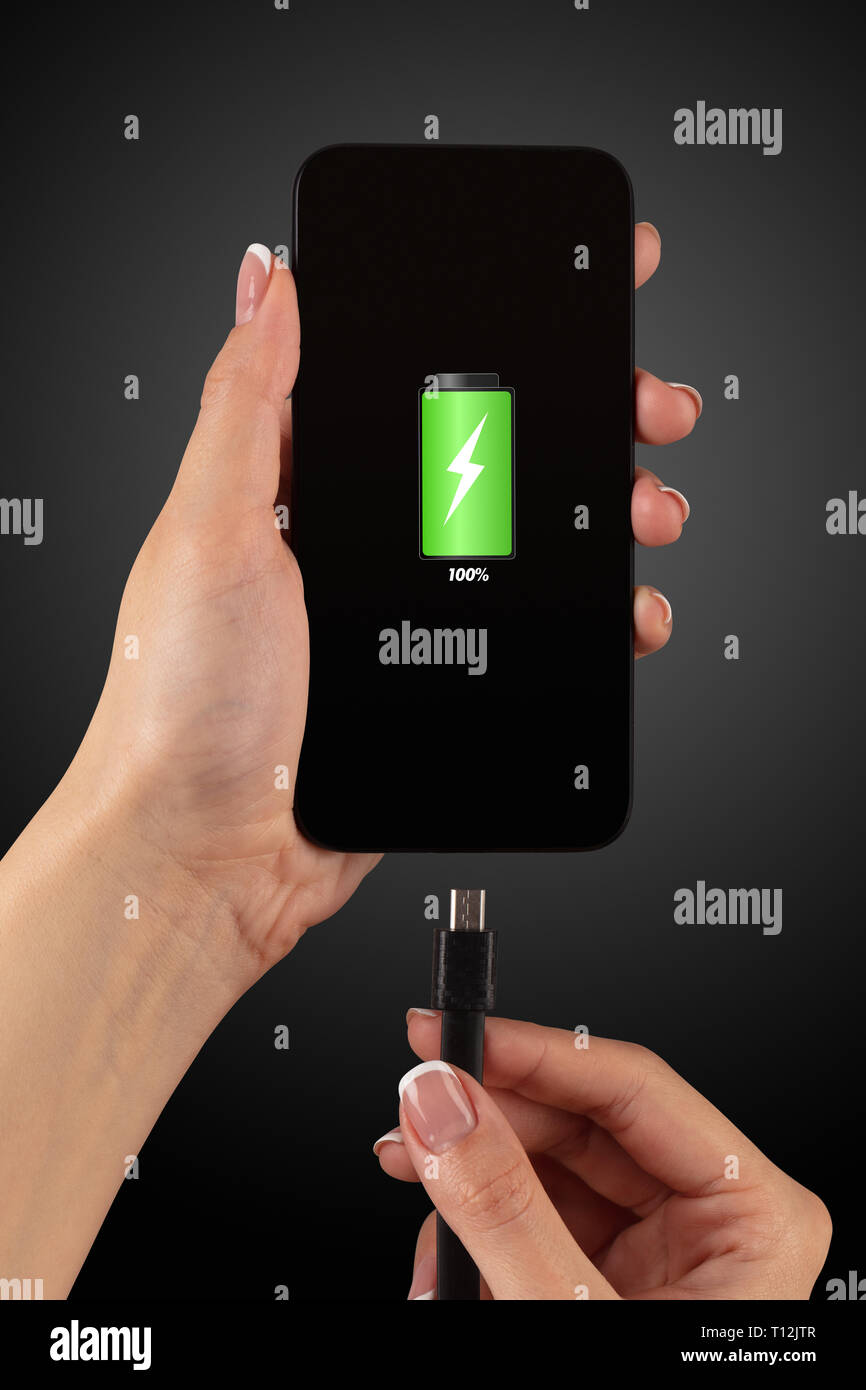 Elegant hand charging cellphone with low battery Stock Photo - Alamy