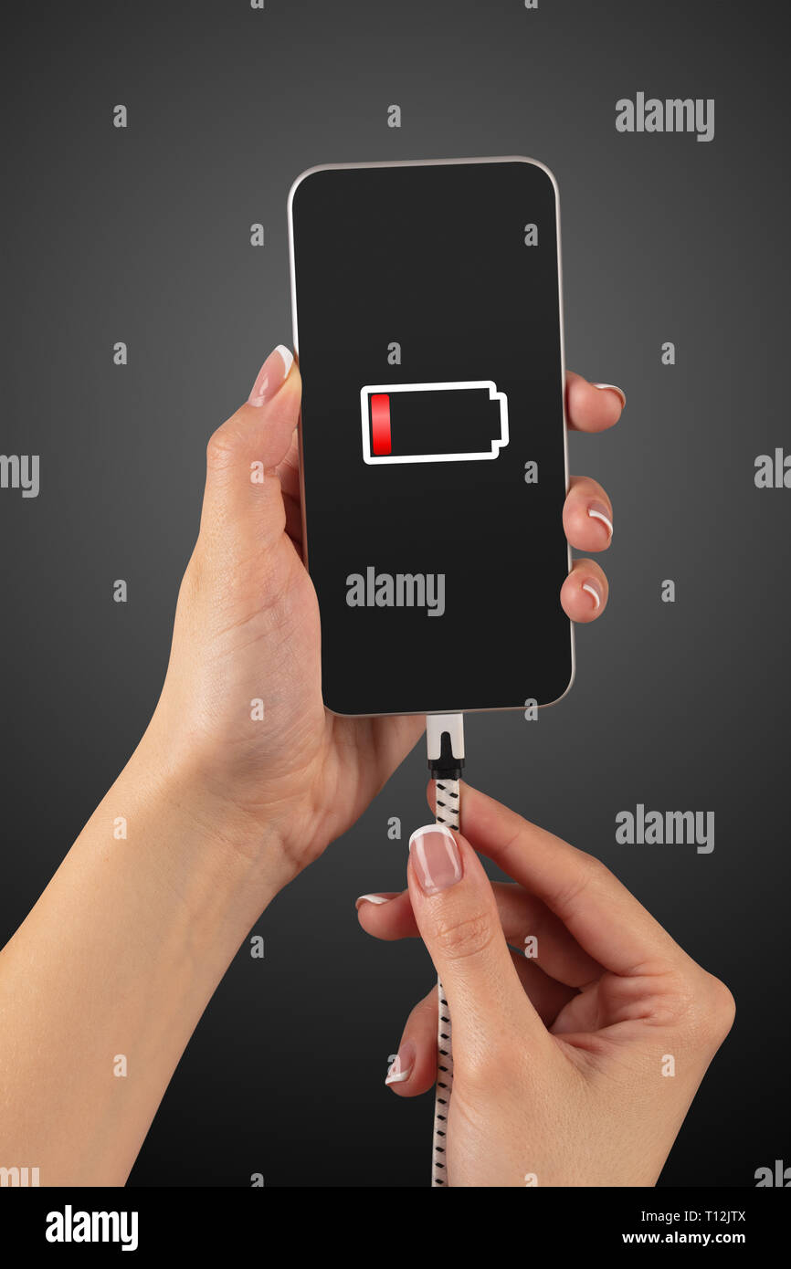 Elegant hand charging cellphone with low battery Stock Photo - Alamy