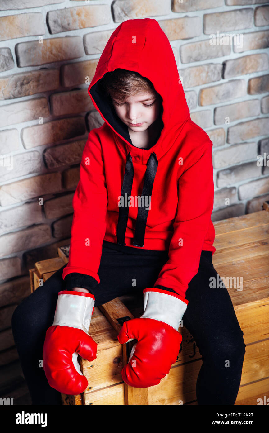 Little boy boxer with blonde hair dressing in red sweatshirt wearing ...