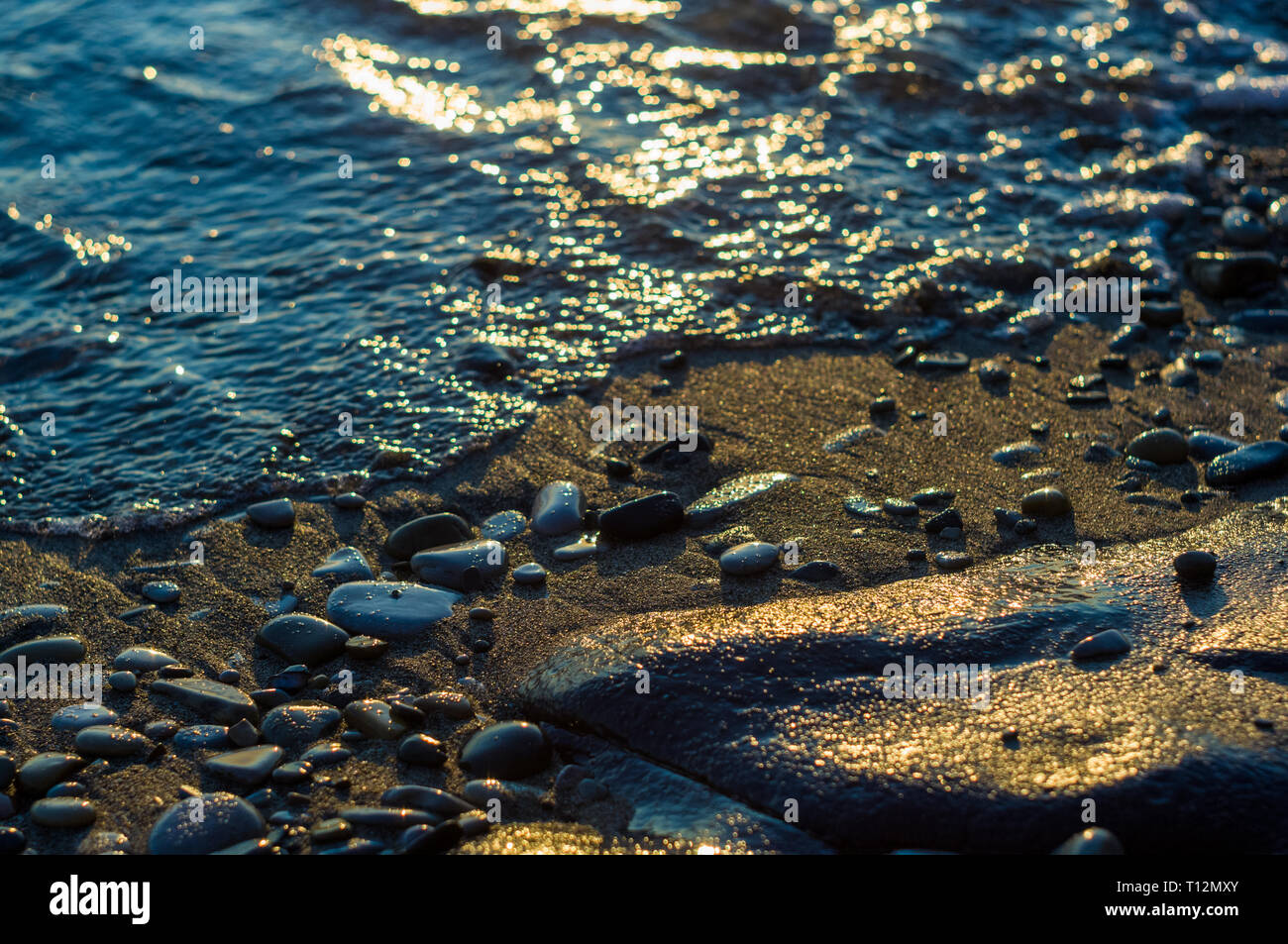 pebble stones on the sea beach on a warm summer day, the rolling waves ...