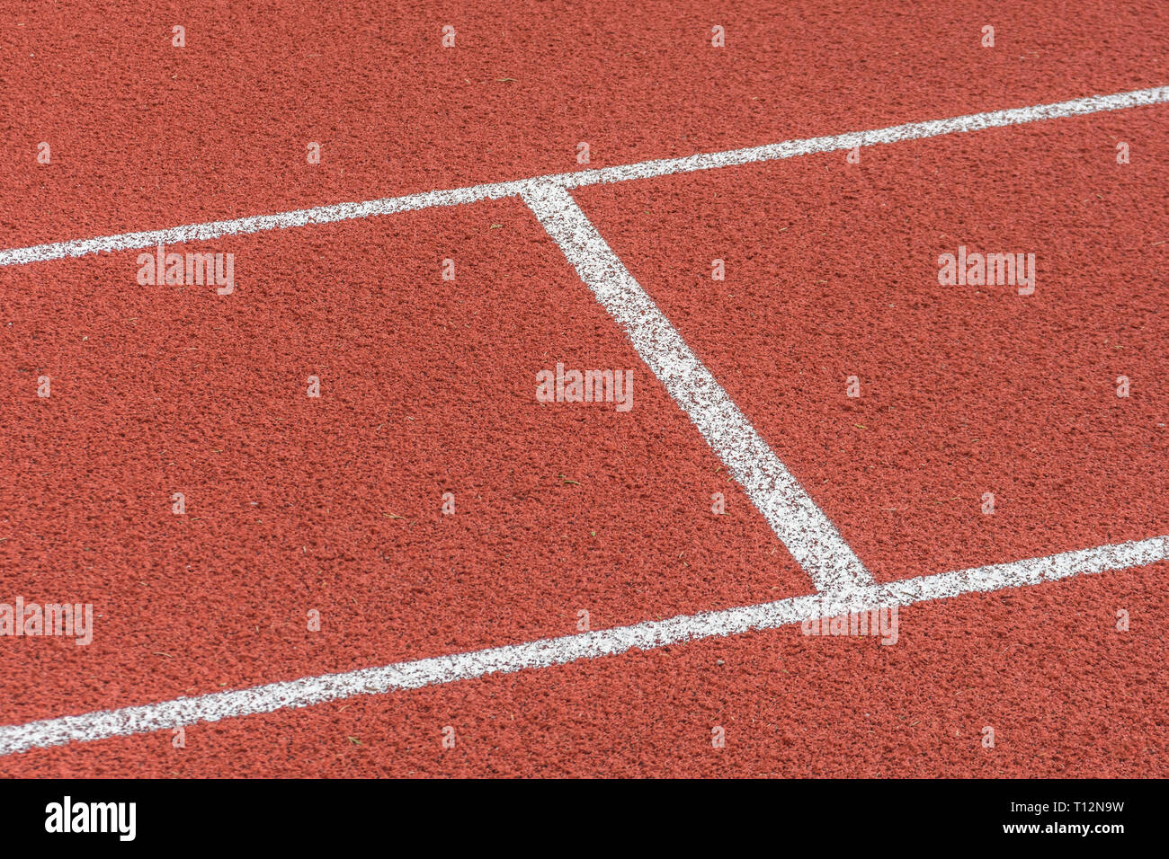 Red coloured all-weather running track. Metaphor 'go the distance ...