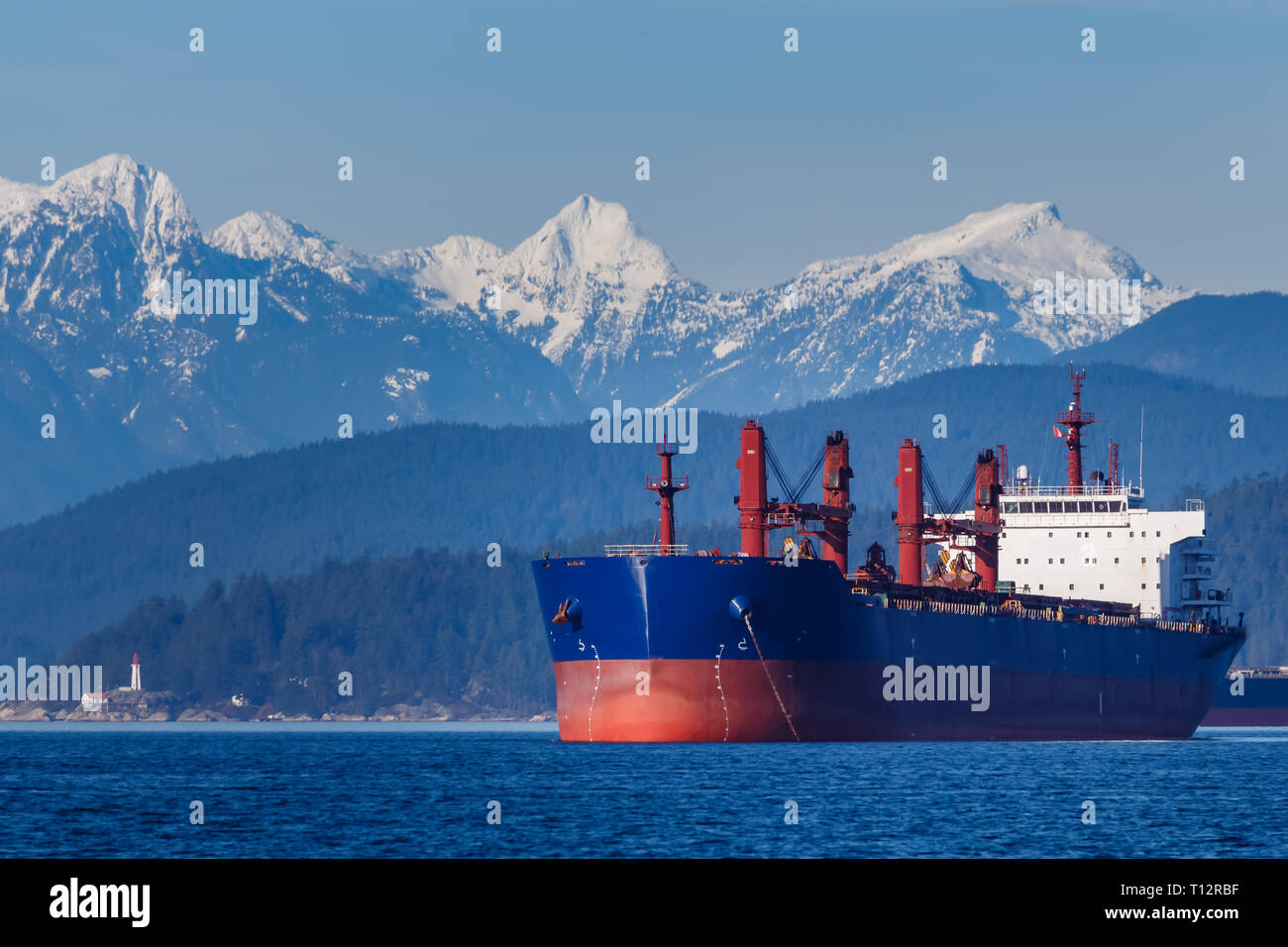 Cargo Ship with mountains in the background Stock Photo - Alamy