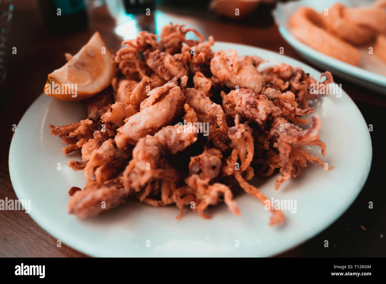 Plate of deep fried squids or Chipirones with lemon. Typical spanish ...