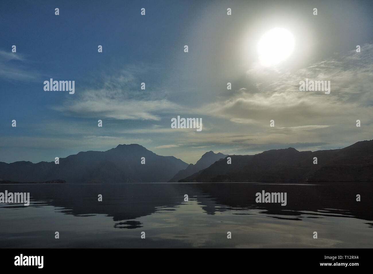 Sun on the background of mountains and the sea. Fjords of the Musandam ...