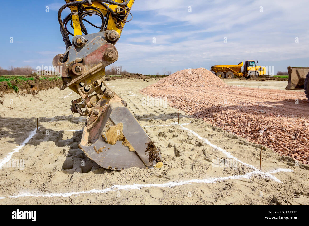 Excavator will excavate square trench that is marked with white powder ...