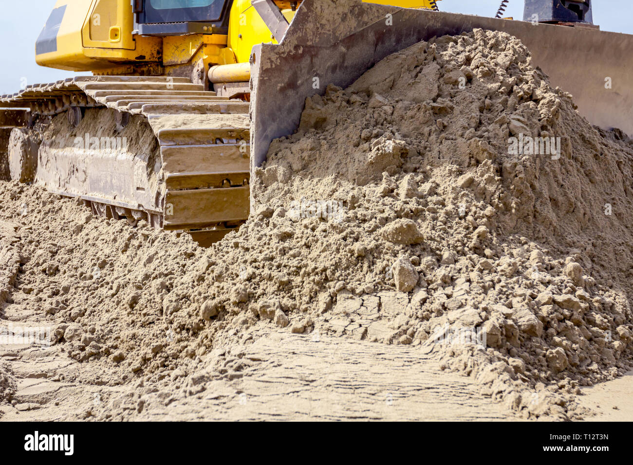Close up view on bulldozer's undercarriage during pushing sand at ...