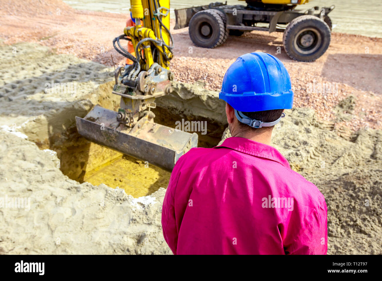 View from behind on construction worker, foreman, with safety blue ...