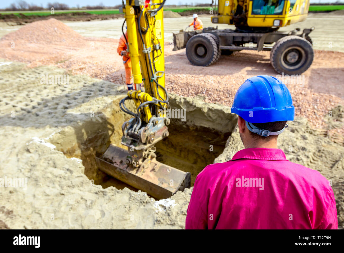 View from behind on construction worker, foreman, with safety blue ...