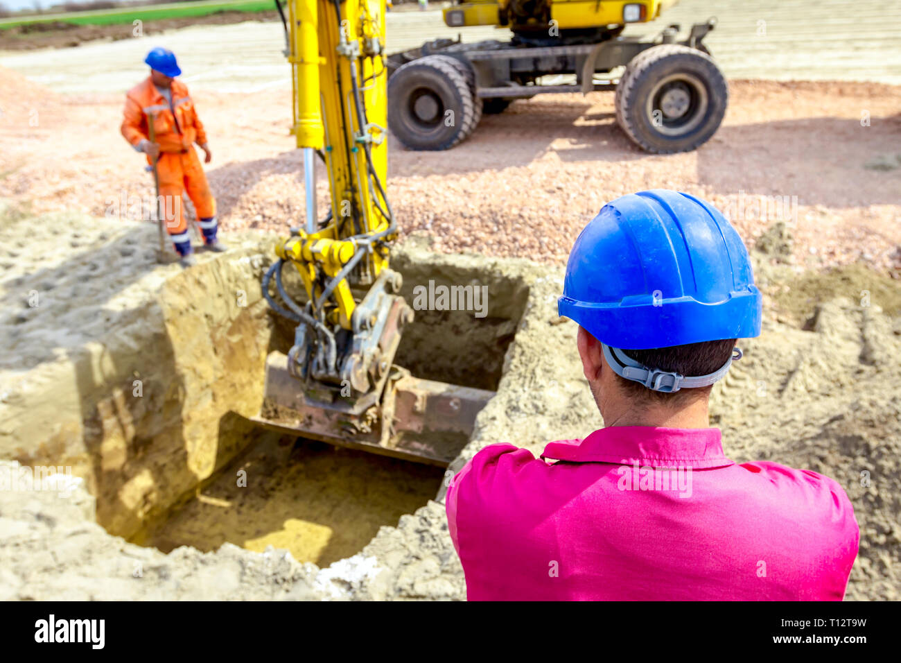 View from behind on construction worker, foreman, with safety blue ...