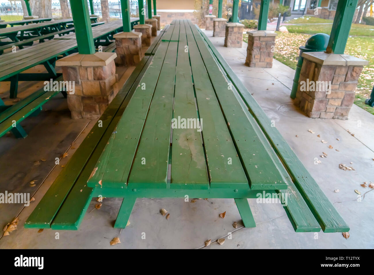 Long wooden tables and benches inside a pavilion. Close up og the long ...
