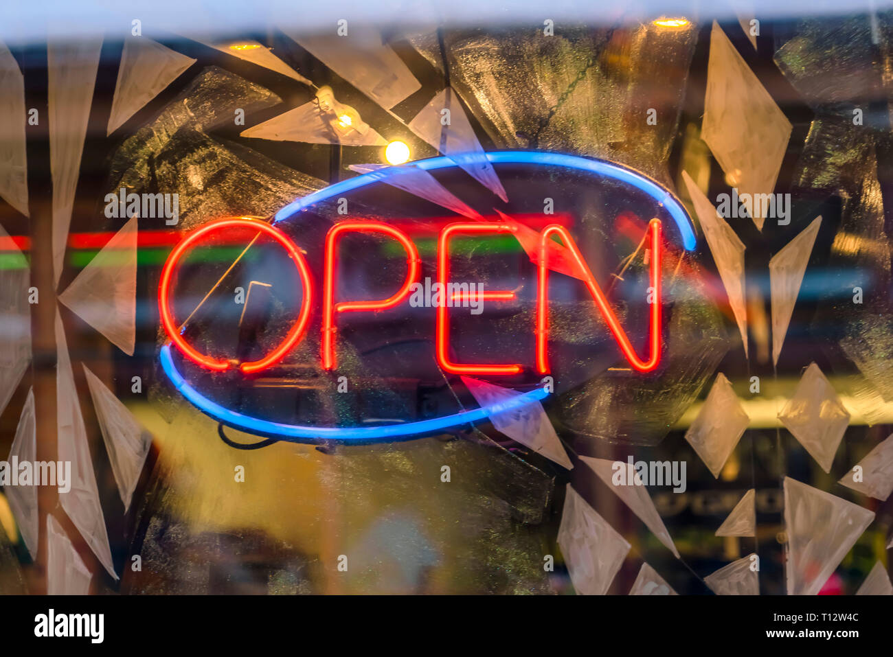 Neon Open sign on decorated glass surface. Close up view of red and ...