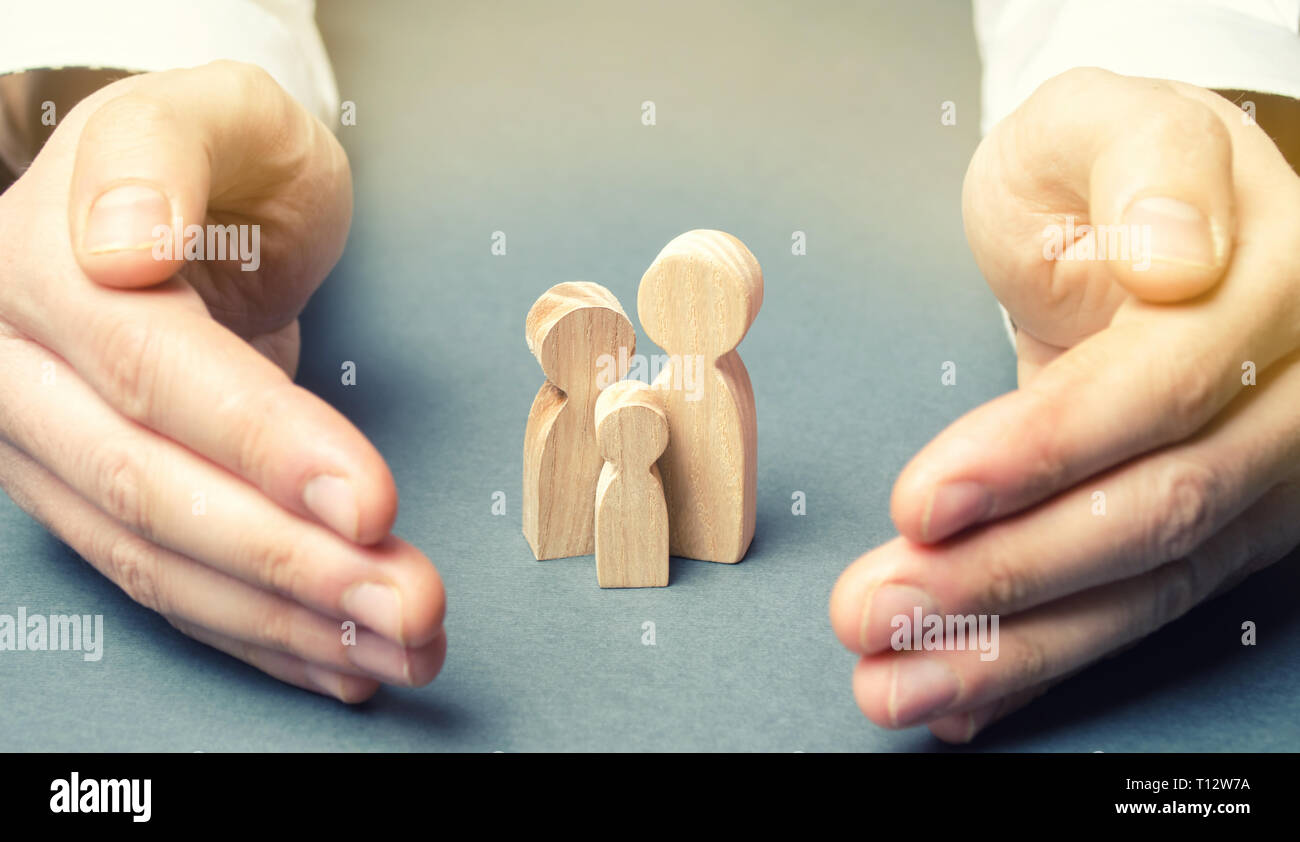 Insurance agent holds hands near the family. The concept of insurance ...