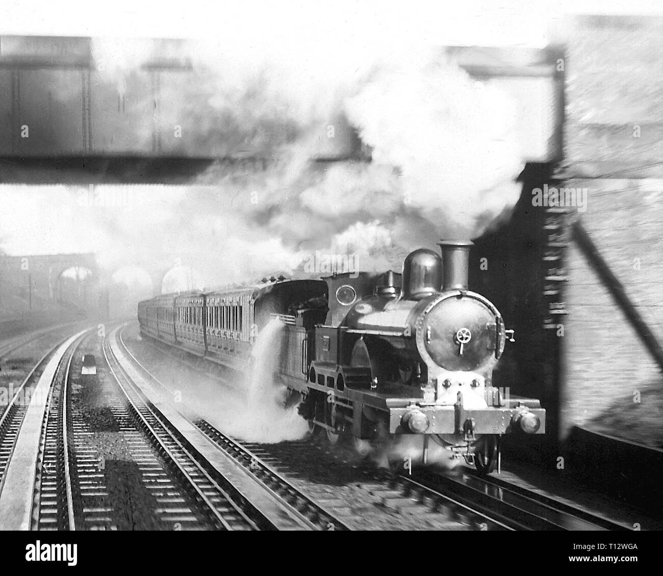 Steam train picking up water from a trough, Bushey, Hertfordshire Stock ...