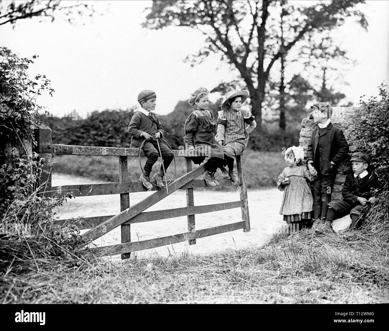 Children chatting on a gate Stock Photo - Alamy