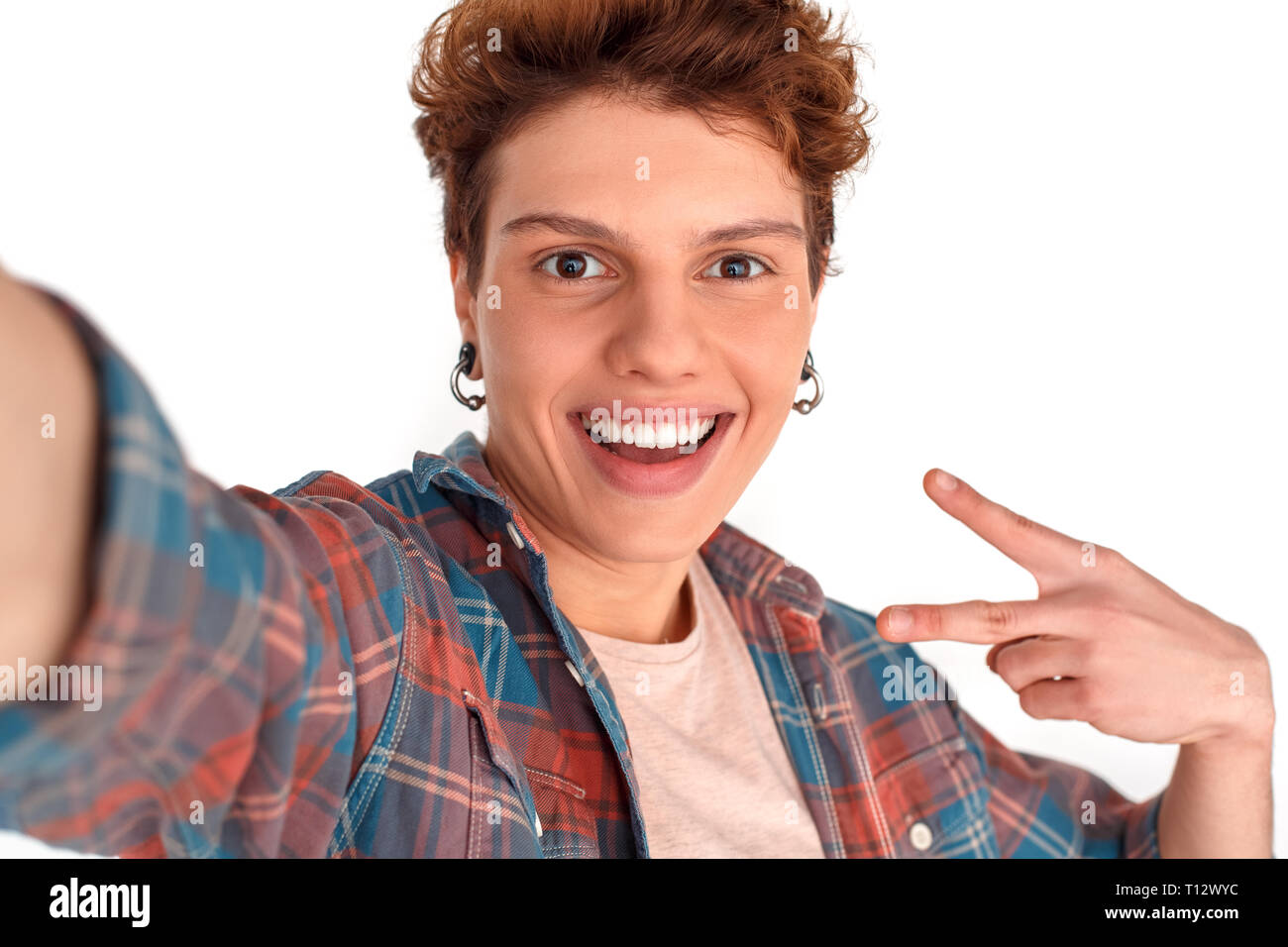 Teenager boy wearing earrings studio standing isolated on white wall ...