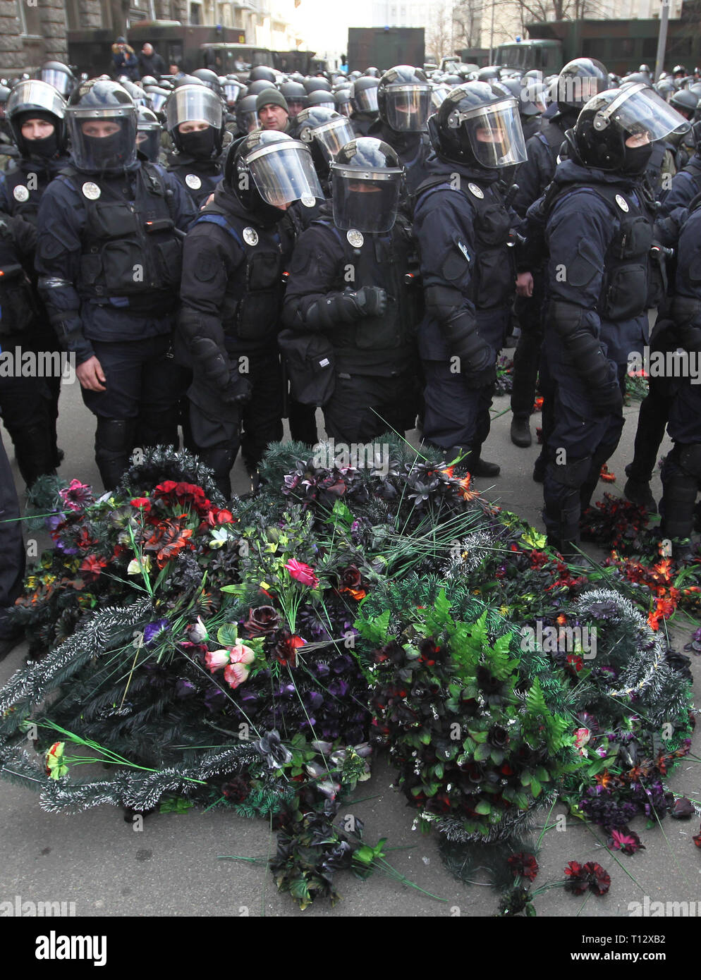 Activists are seen throwing wreath flowers next to the riot police ...