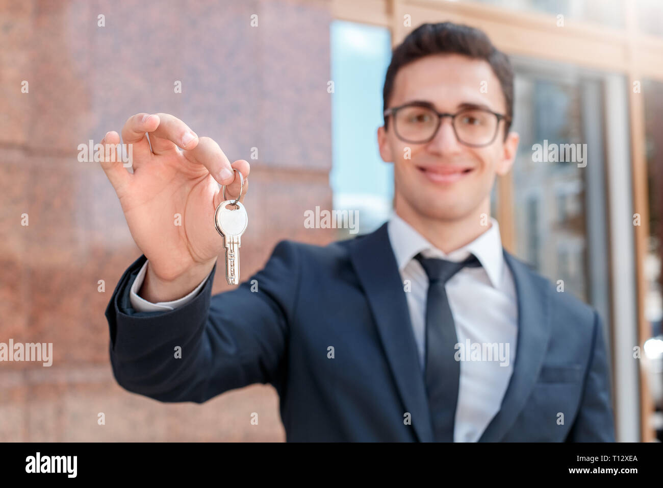Young salesman standing wearing eyeglasses on the city street holding ...