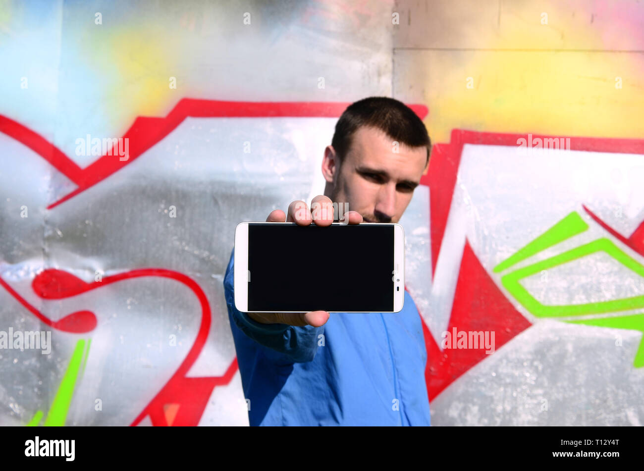The graffiti artist demonstrates a smartphone with an empty black ...