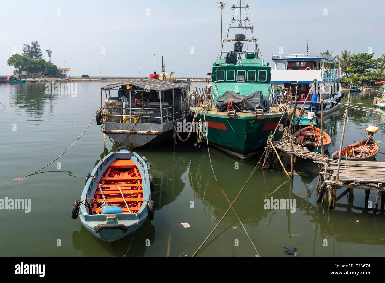 Small wooden bridge and different type of boats on Duong Dong river ...