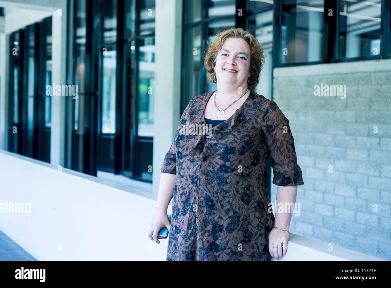 A friendly white lady stands in a modern designed building for a ...