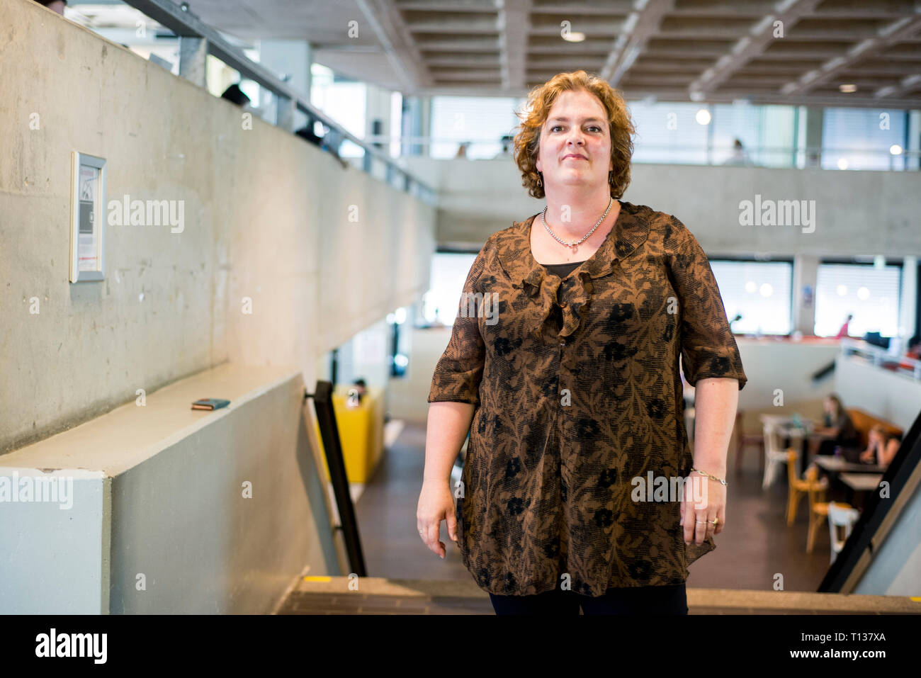 A friendly white lady stands in a modern designed building for a ...