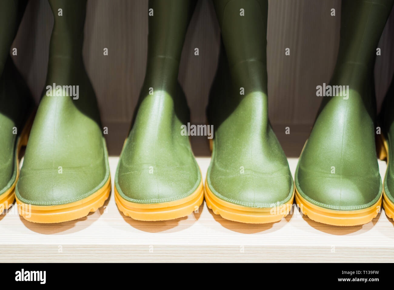 Green rubber boots on a shelf of a fast fashion store Stock Photo - Alamy