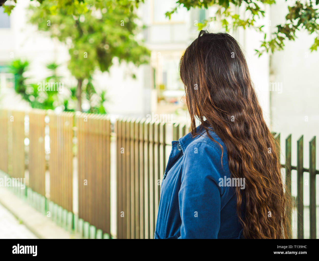 Authentic young woman outdoors turned with her back. Urban scene Stock ...