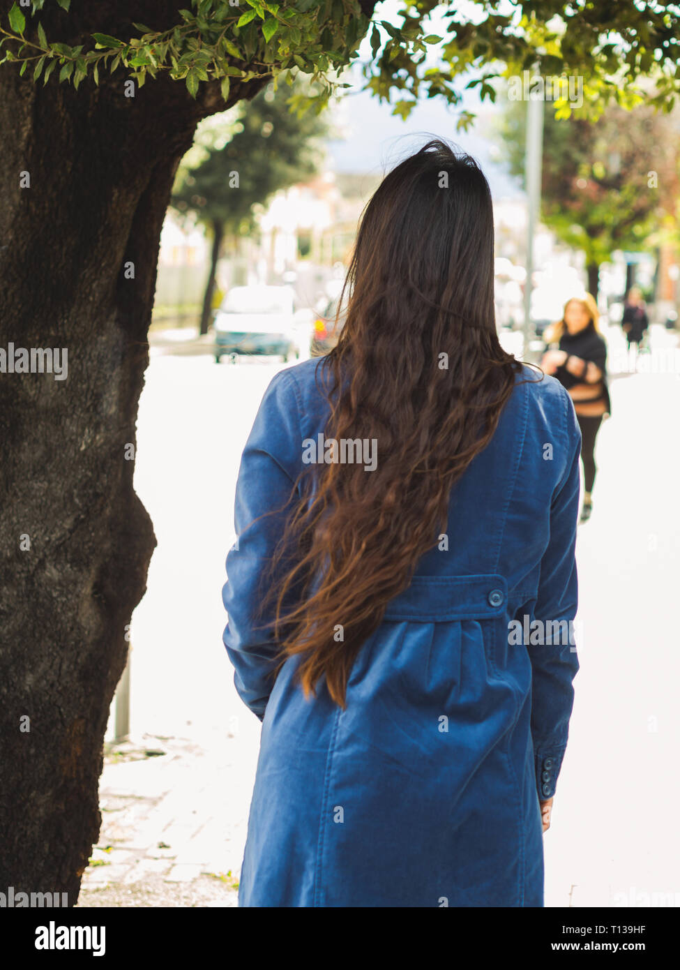 Authentic young woman outdoors turned with her back. Urban scene Stock ...
