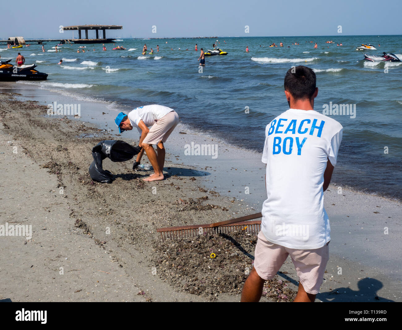 Two men tidy up Constanta beach Stock Photo - Alamy