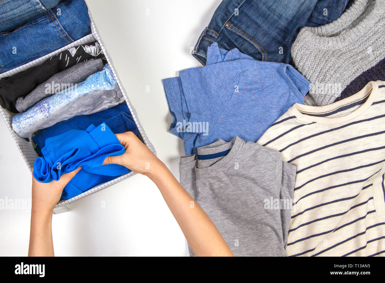 Vertical storage of clothing, tidying up, room cleaning concept. Hands ...