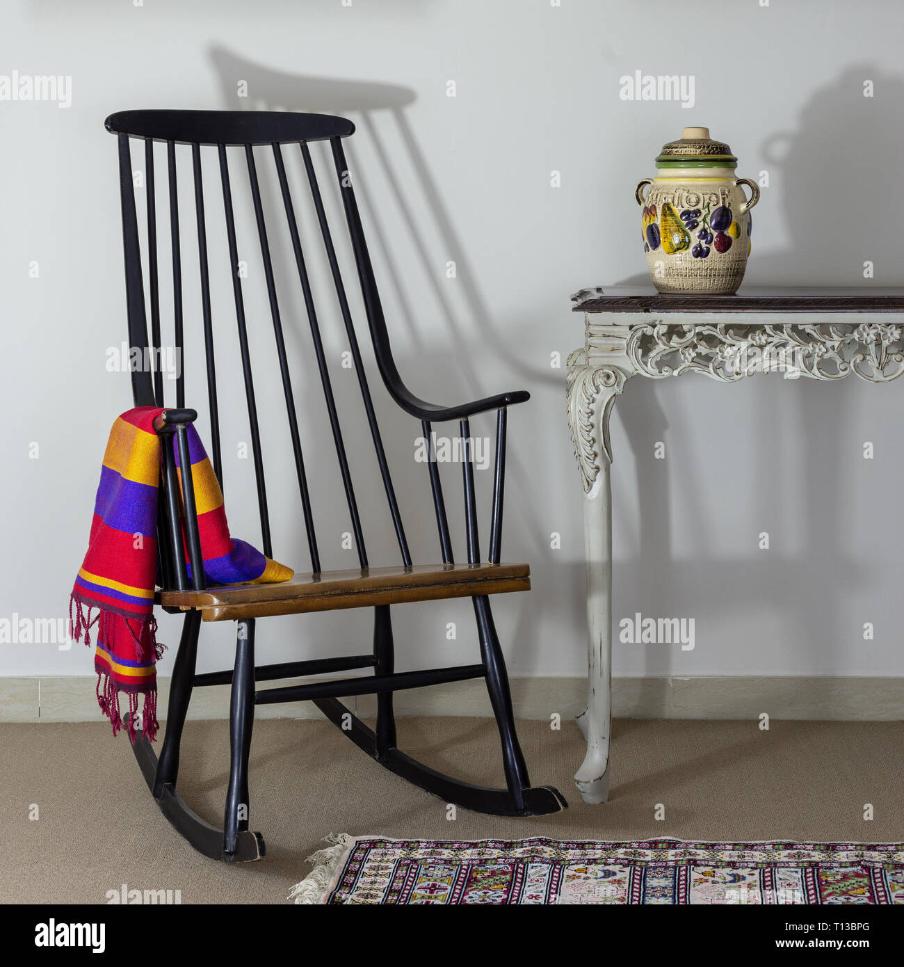 Classic rocking chair and old style vintage table on background of off ...