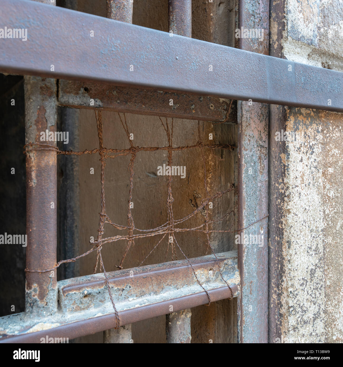 Closeup of a closed rusted iron bars of cell door in closed abandoned ...