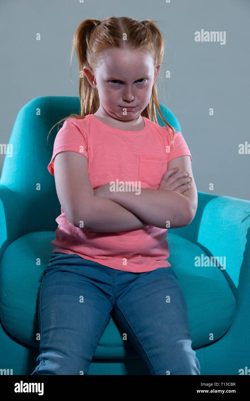a restless white girl with red hair sat on a chair Stock Photo - Alamy