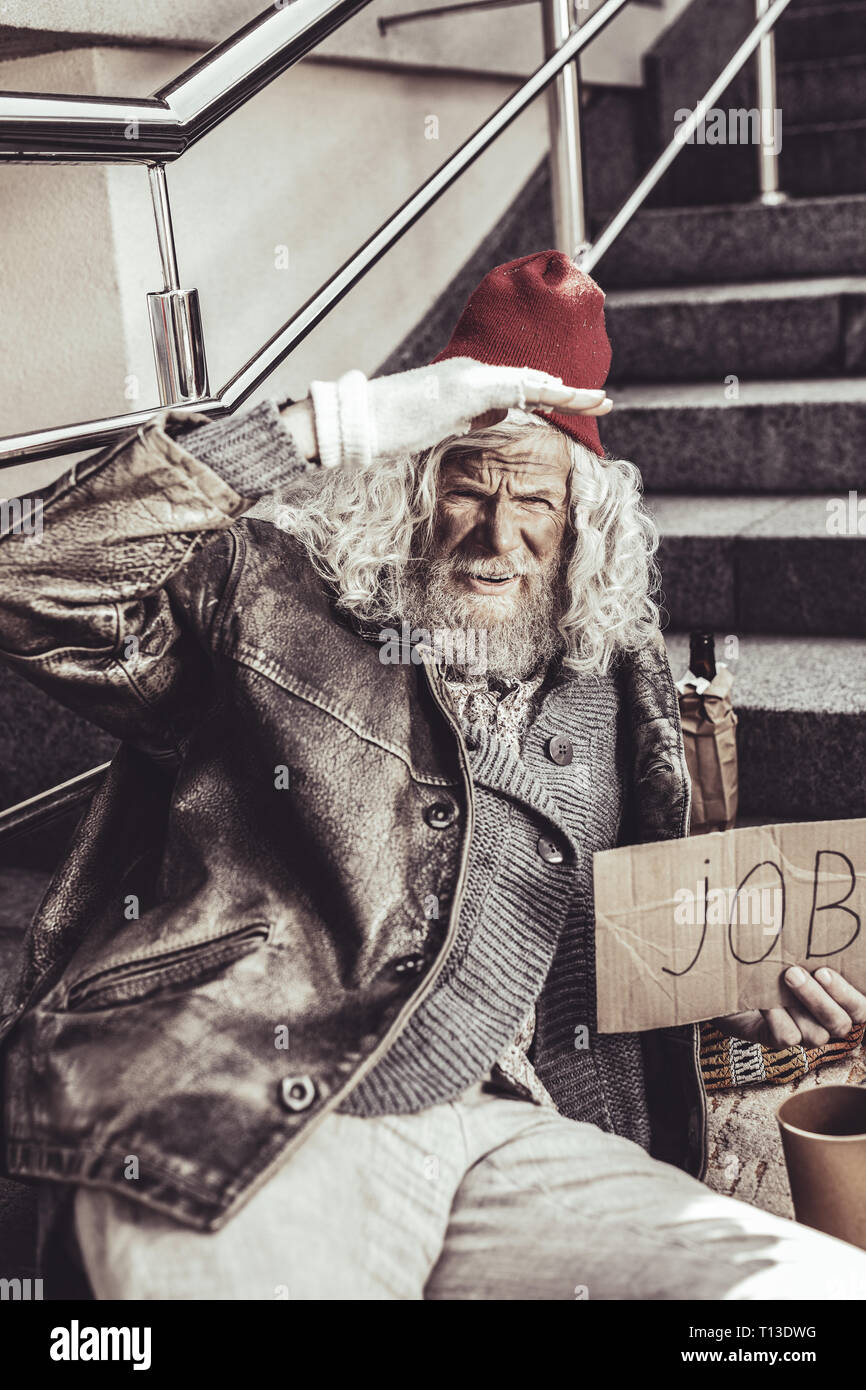 Caucasian old homeless man seeing friend distantly and watching him ...