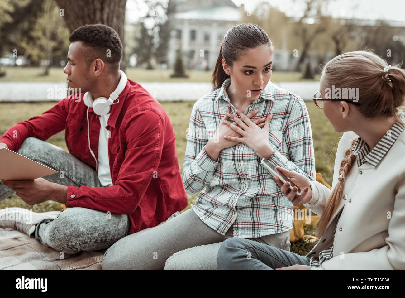 Emotional brunette girl listening to her group mate Stock Photo - Alamy