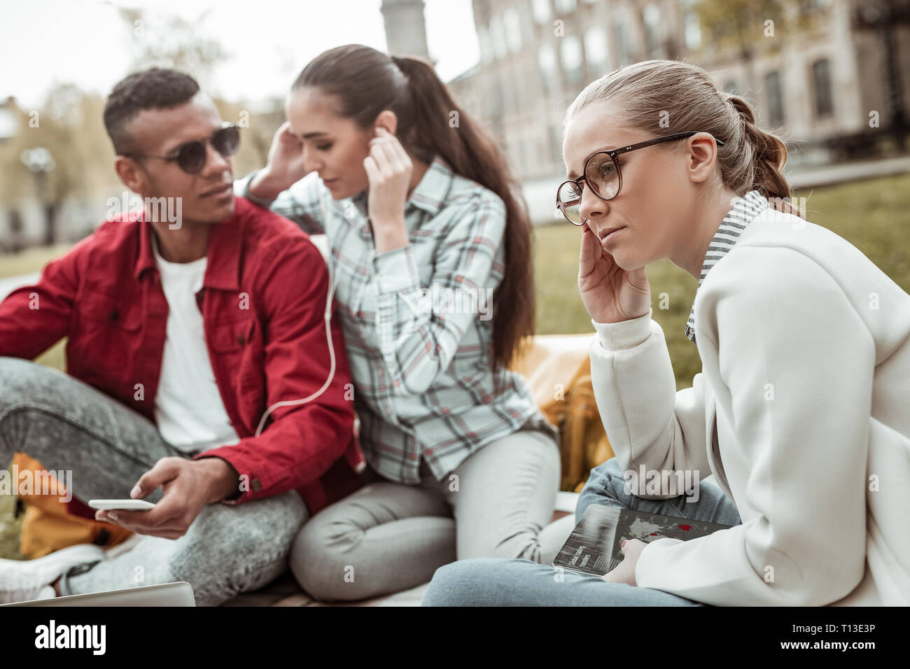 Thoughtful blonde girl sitting in semi position Stock Photo - Alamy