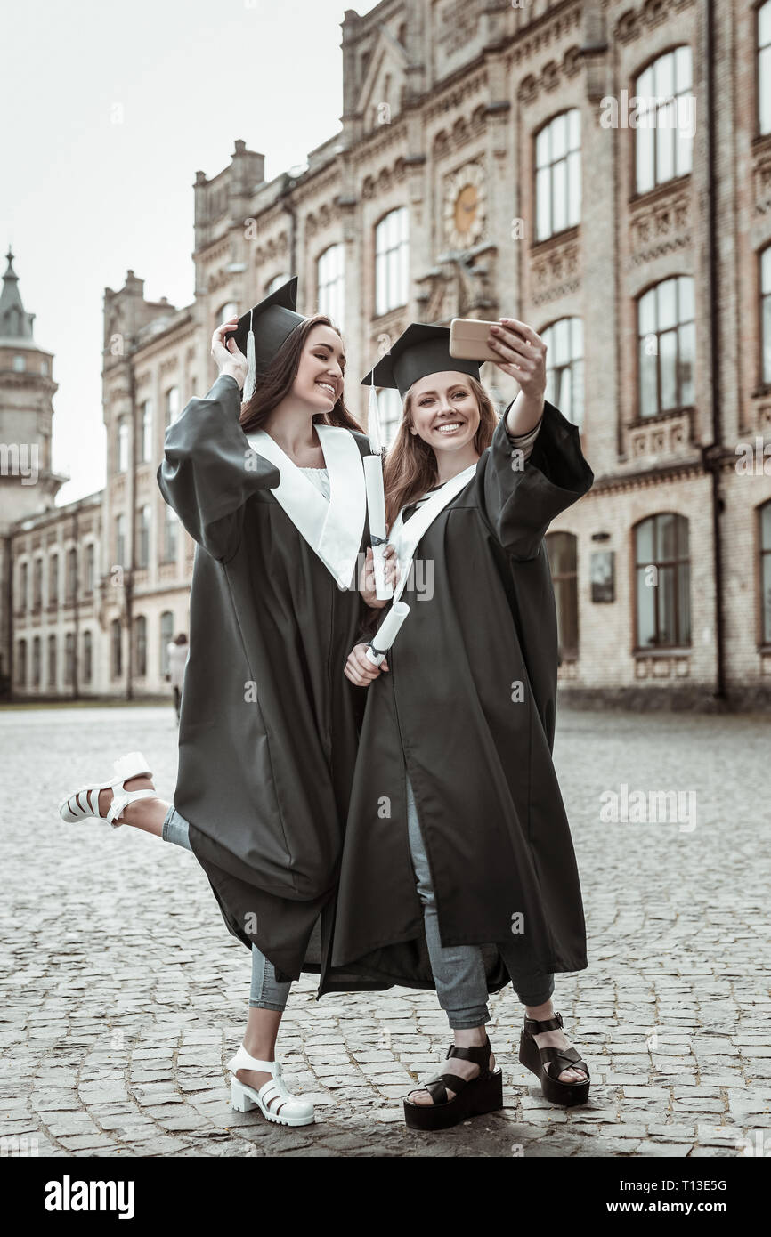 Positive delighted leavers doing pictures on smartphone Stock Photo - Alamy