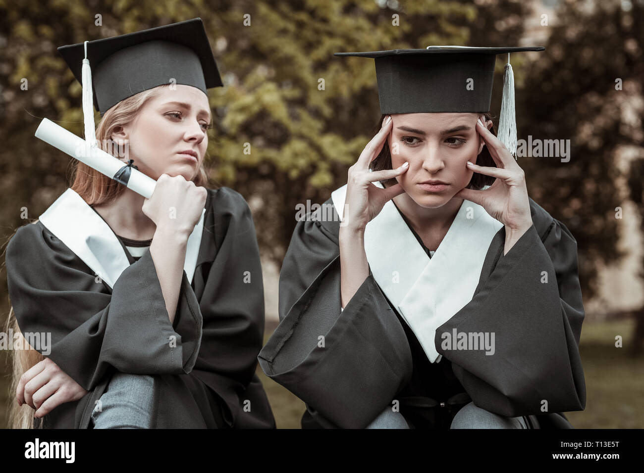 Sad student sitting near her group mate Stock Photo - Alamy