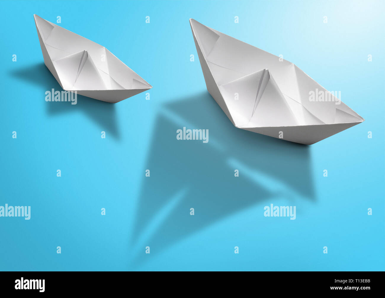 Leadership concept concept, paper ship with sailing boat shadow on blue ...