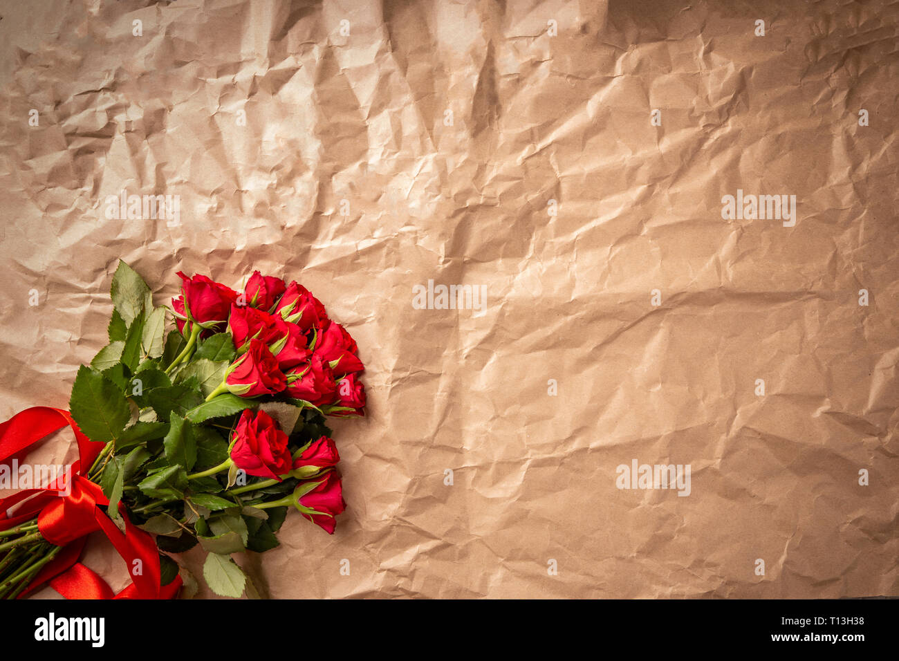 Red roses on wrapped paper background, space for your text Stock Photo ...