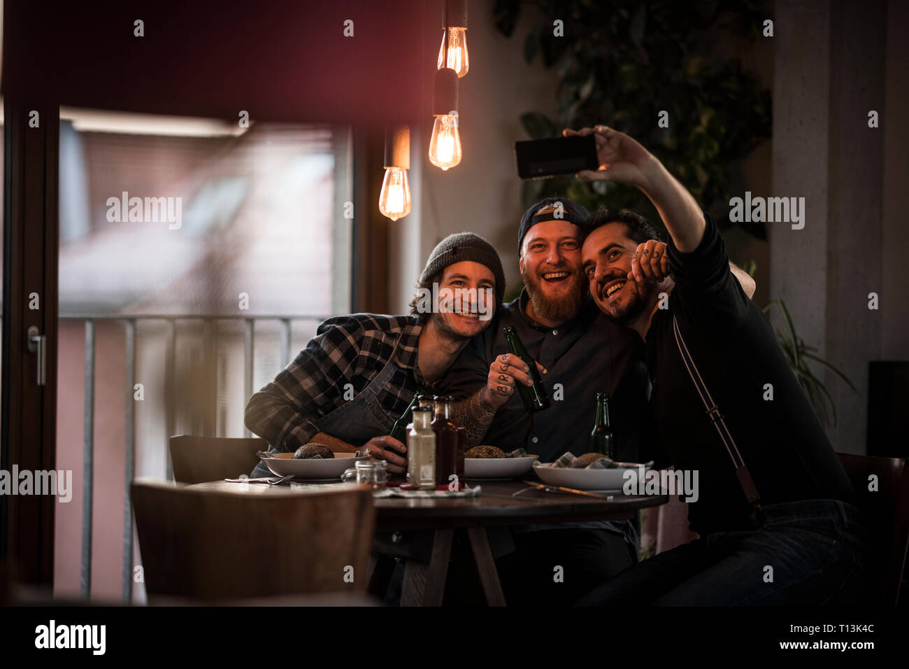 Friends eating what they have cooked and taking selfies Stock Photo - Alamy