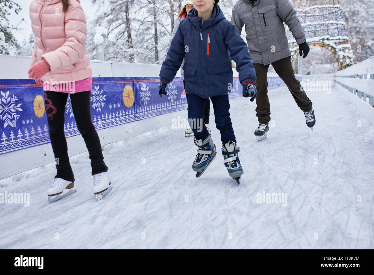 Family with two kids ice skating on the ice rink Stock Photo - Alamy