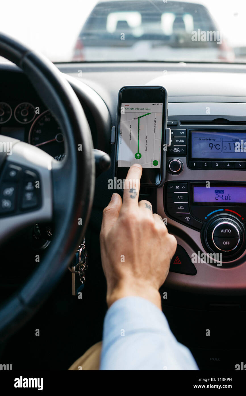 Close-up of man with tattooed hand driving car using cell phone as ...