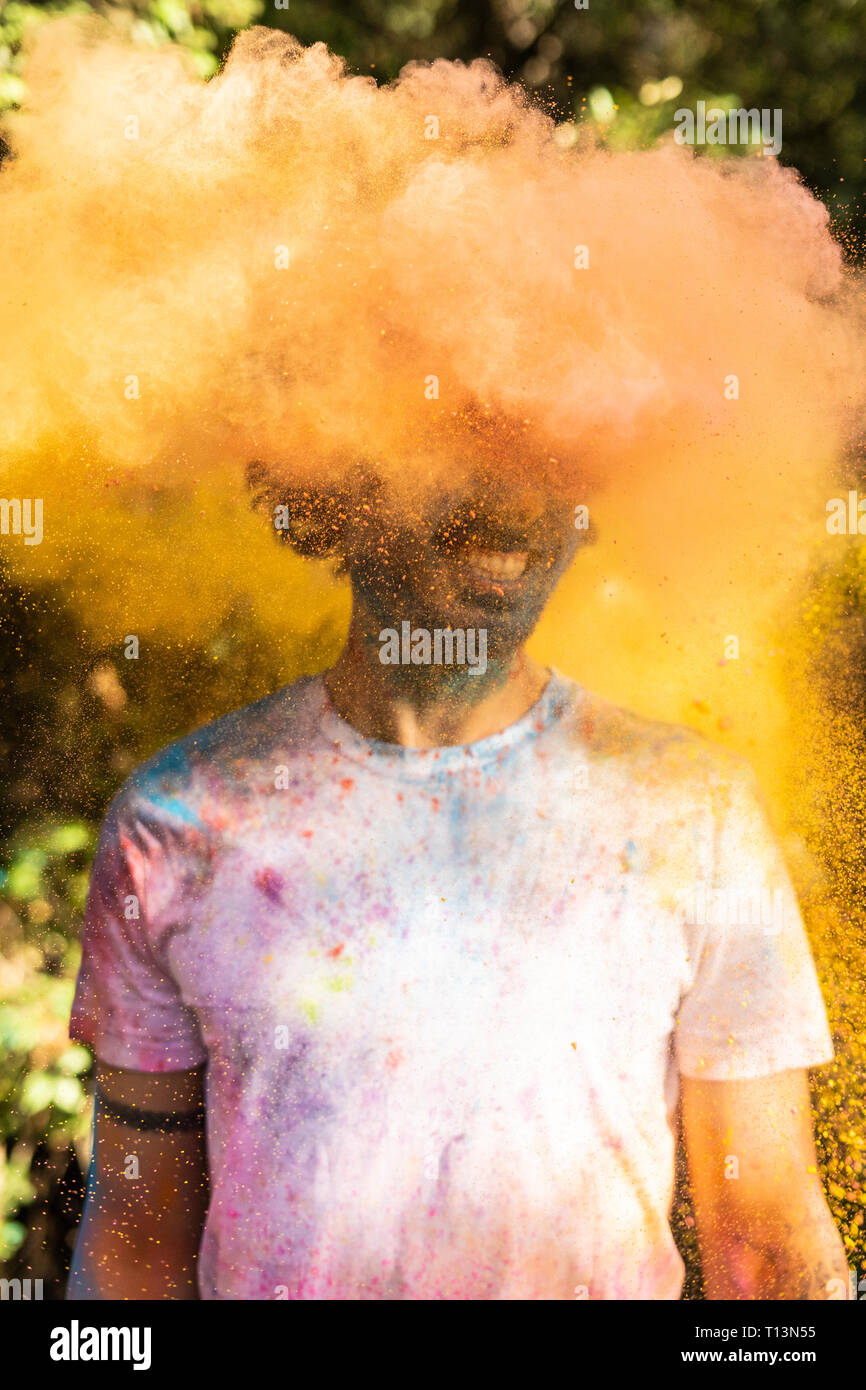 Man shaking his head, full of colorful powder paint, celebrating Holi ...
