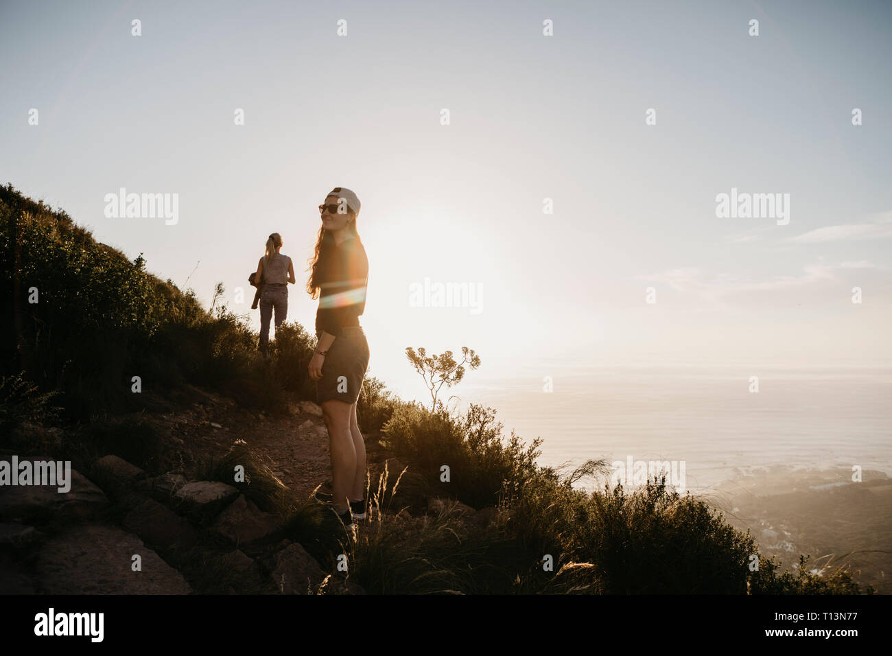 South Africa, Cape Town, Kloof Nek, two women on a trail at sunset ...