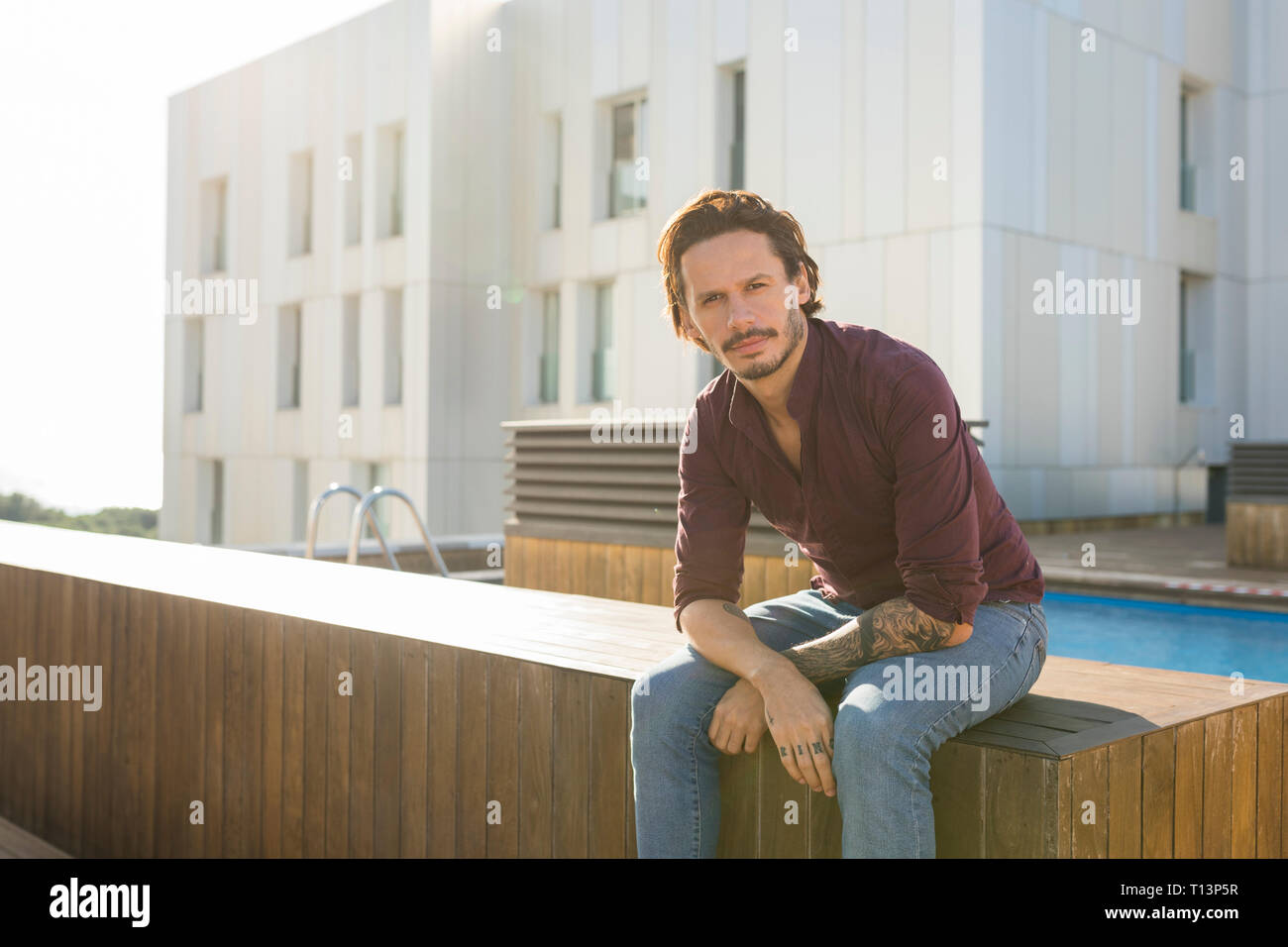 Man sitting on a rooftop terrace Stock Photo - Alamy