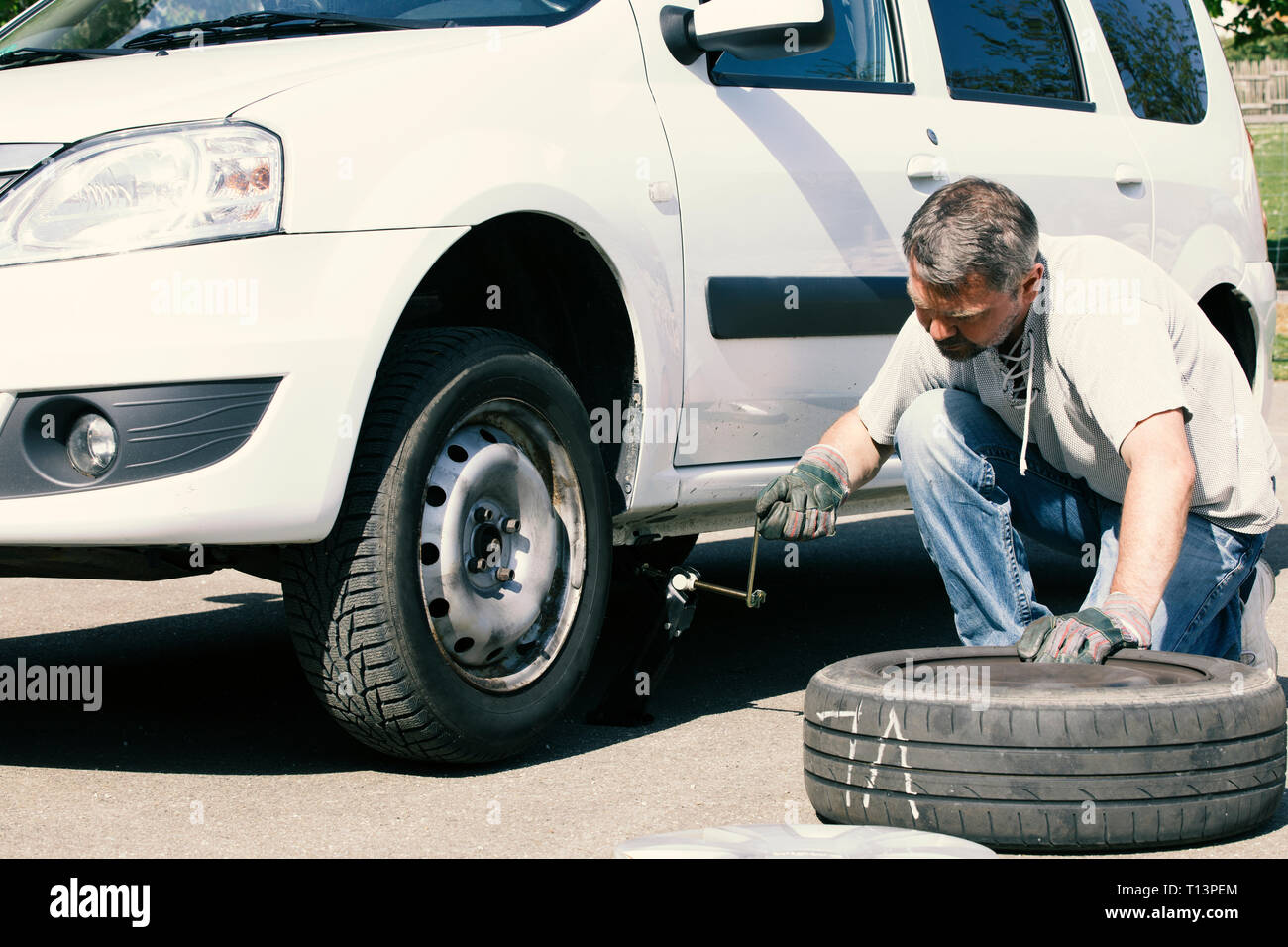 Mature man changing car tires hi-res stock photography and images - Alamy